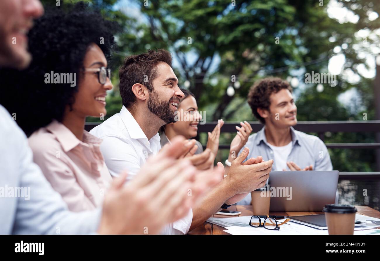 Well done team. a diverse group of businesspeople sitting together and ...