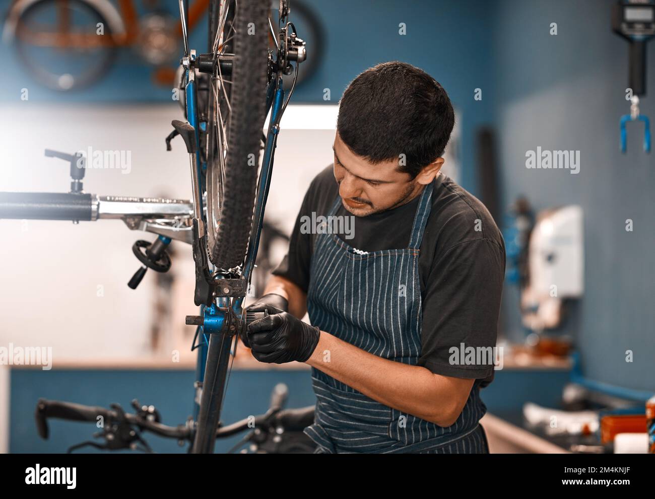 Leave it to him to fix your bike. a man working in a bicycle repair ...