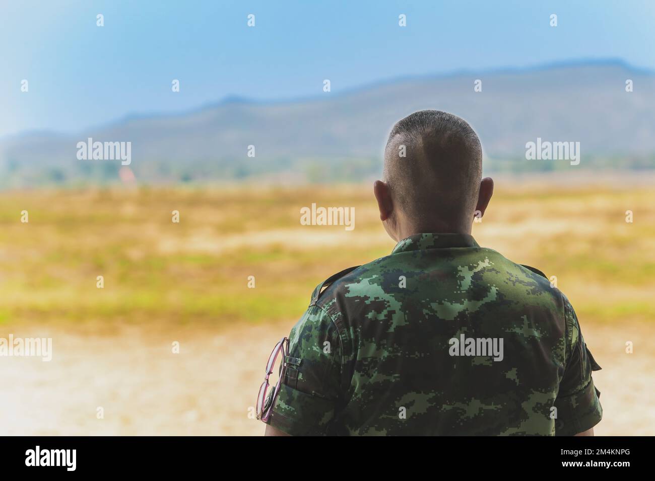 Back view of Asian army soldier stands to explore the landscape in ...