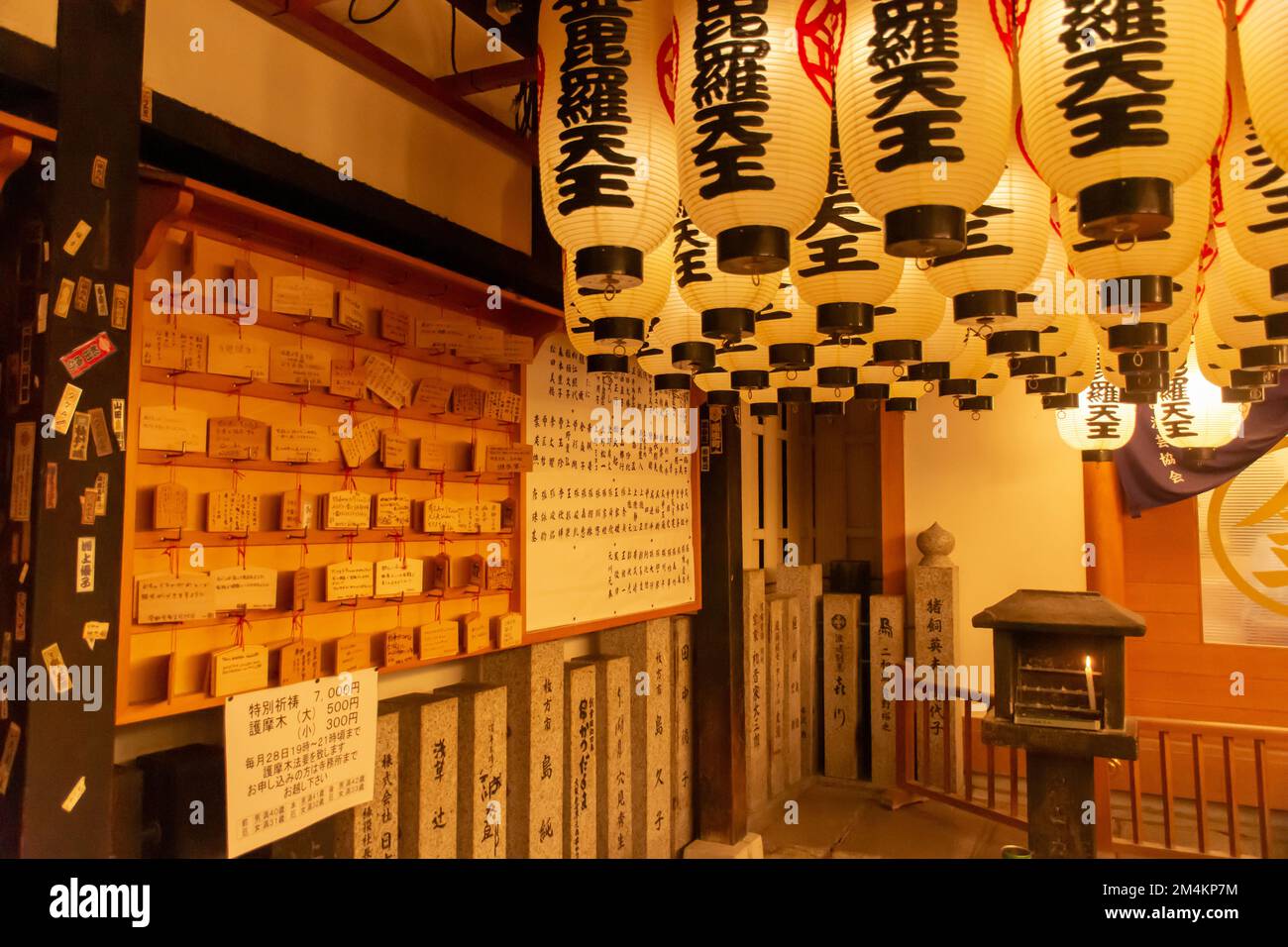 The inside of a Japanese cafe with lots of light yellow lamps hanging ...
