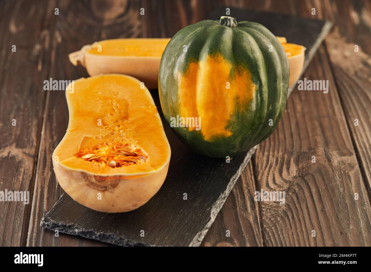 Pumpkin pear-shaped on black stone on wooden background Stock Photo - Alamy