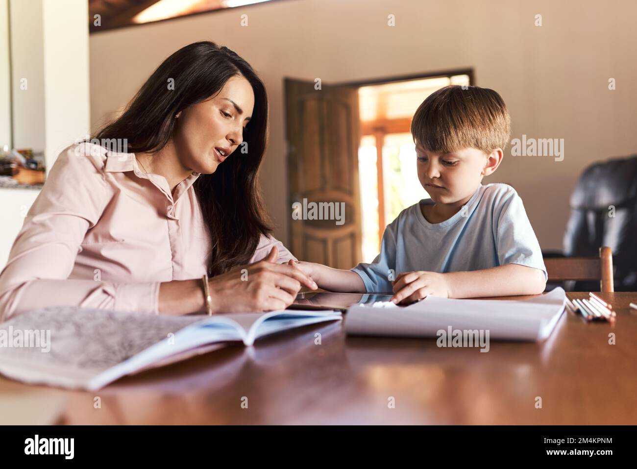 Making homework a bonding activity. a mother helping her son with his homework Stock Photo - Alamy