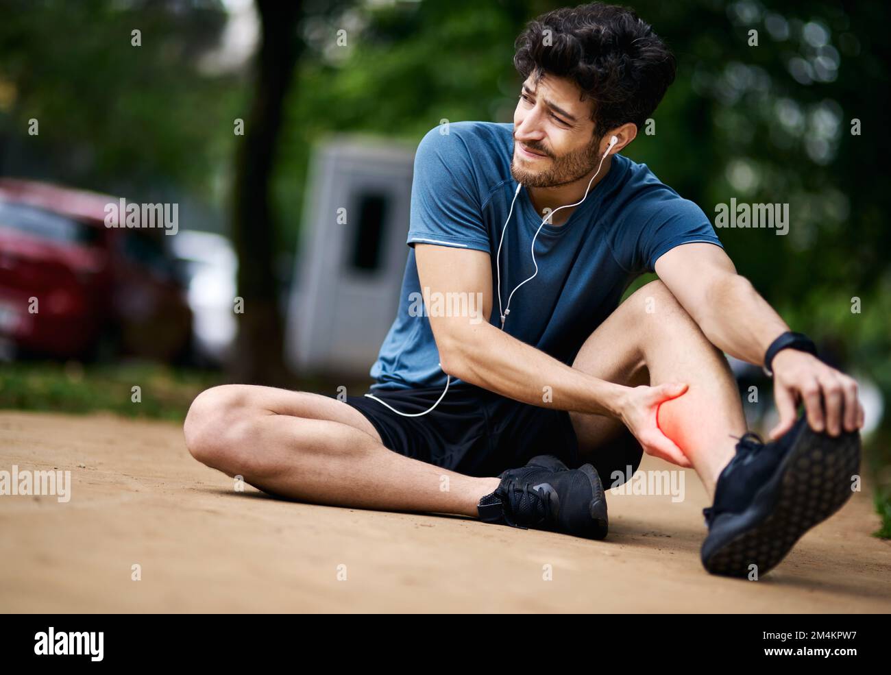 Dont mess around with any injuries. a sporty young man holding his calf ...