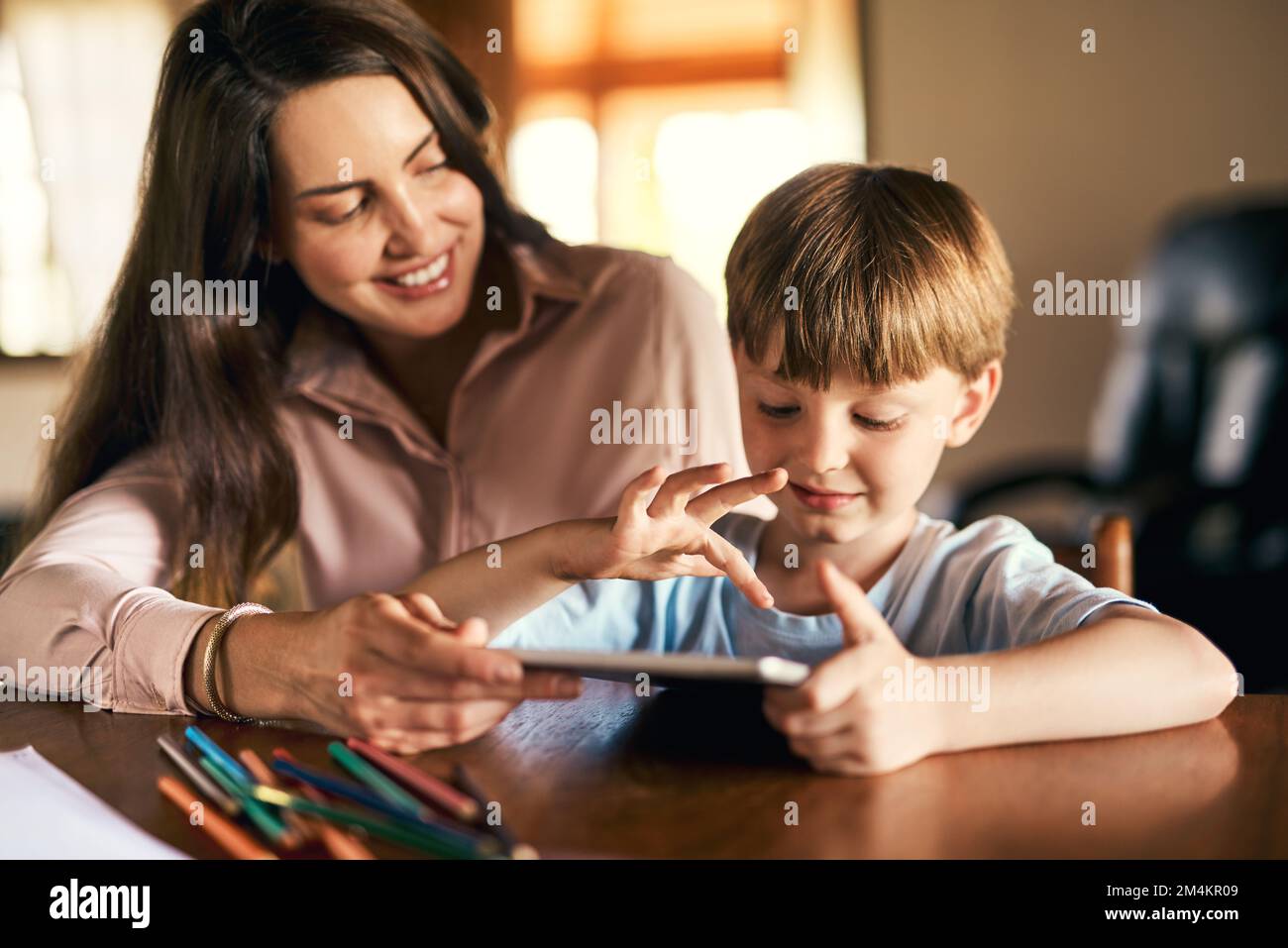 Getting hands on with homework. a little boy using a digital tablet ...