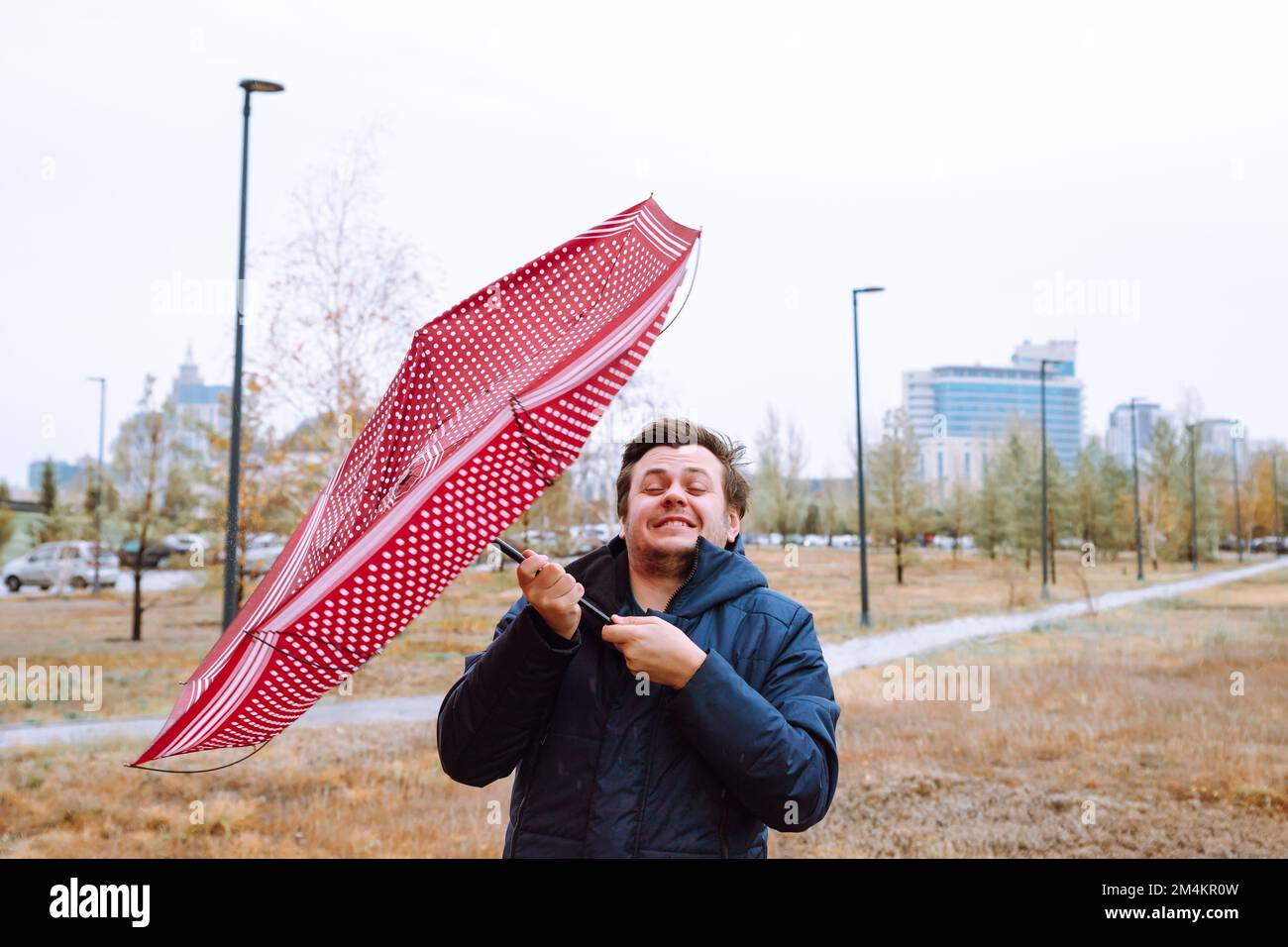 Shocked European white young male man fool around with umbrella in city ...