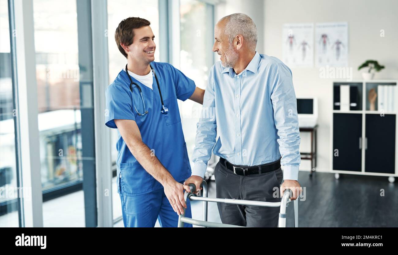Full health is just a few steps away. a male nurse assisting a senior ...