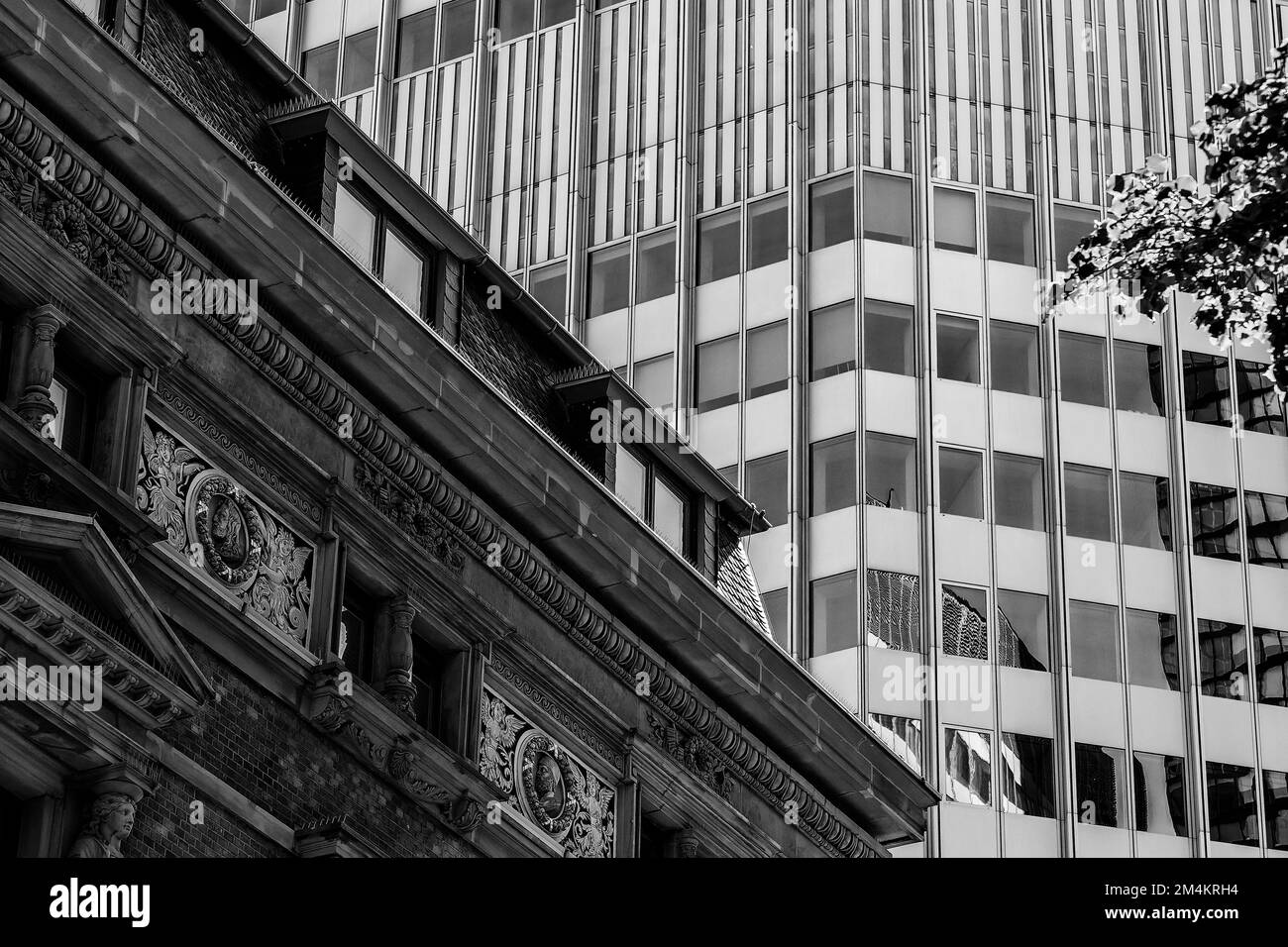 A grayscale beautiful view of an old and modern building with small ...