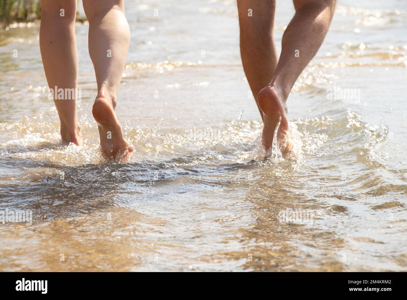 male and female feet in sea water bottom view in the sun Stock Photo ...