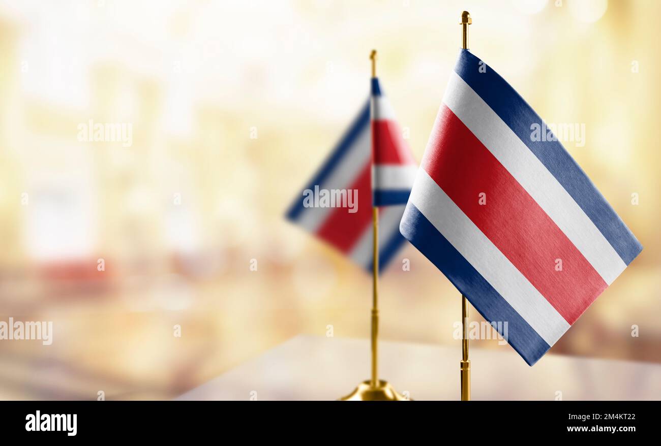 Small flags of the Costa Rica on an abstract blurry background Stock ...