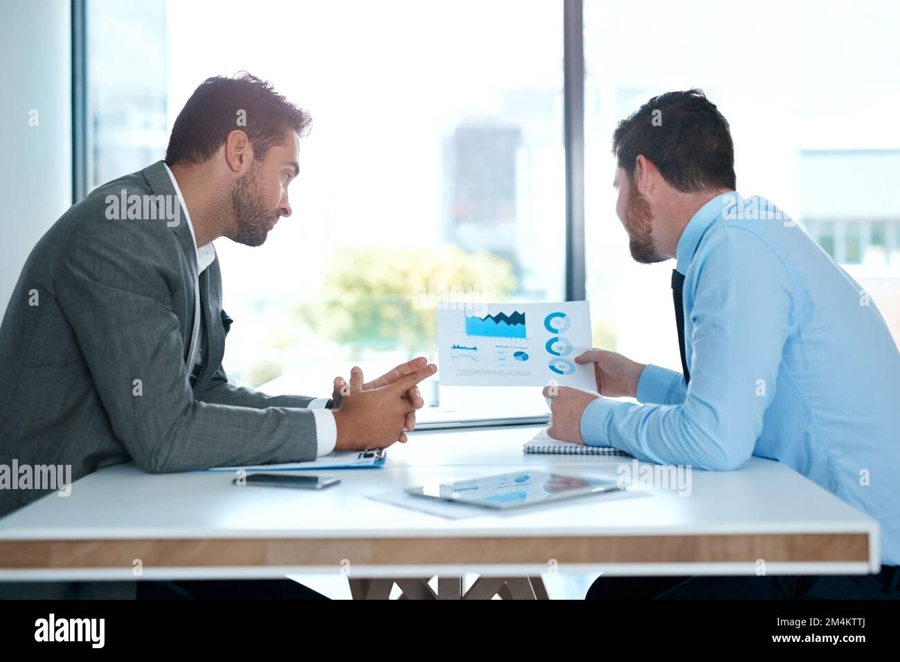 Putting the numbers to work. two young businessmen going through ...