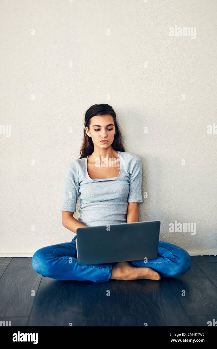 Waiting patiently for connection. a young woman sitting on the floor ...