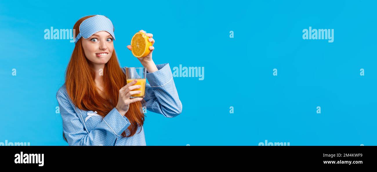 Excited and cute pretty caucasian redhead woman in pyjama and sleep ...