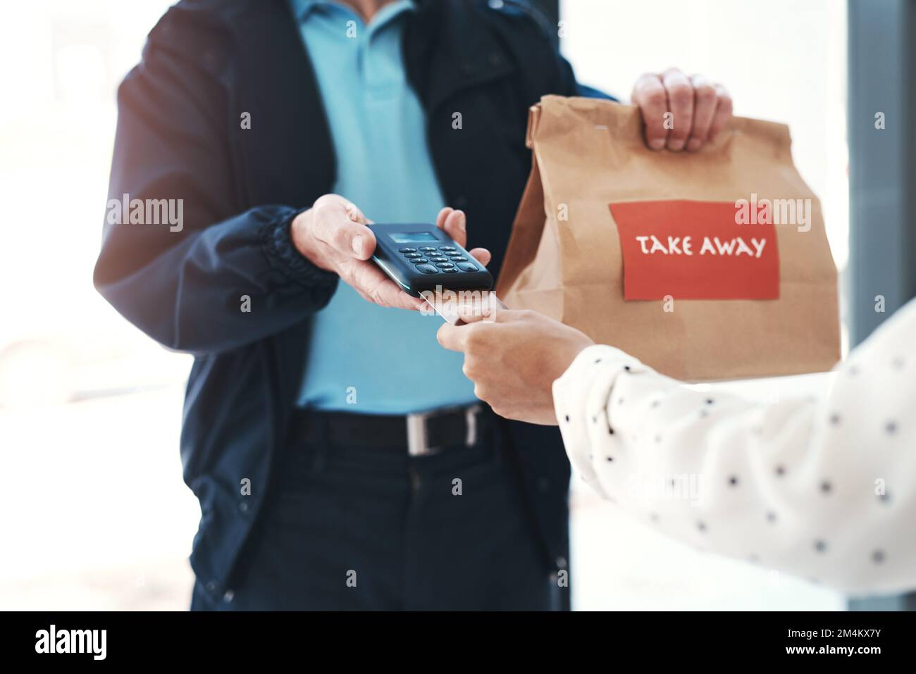 Making a quick payment before she enjoys her dinner. an unrecognizable ...