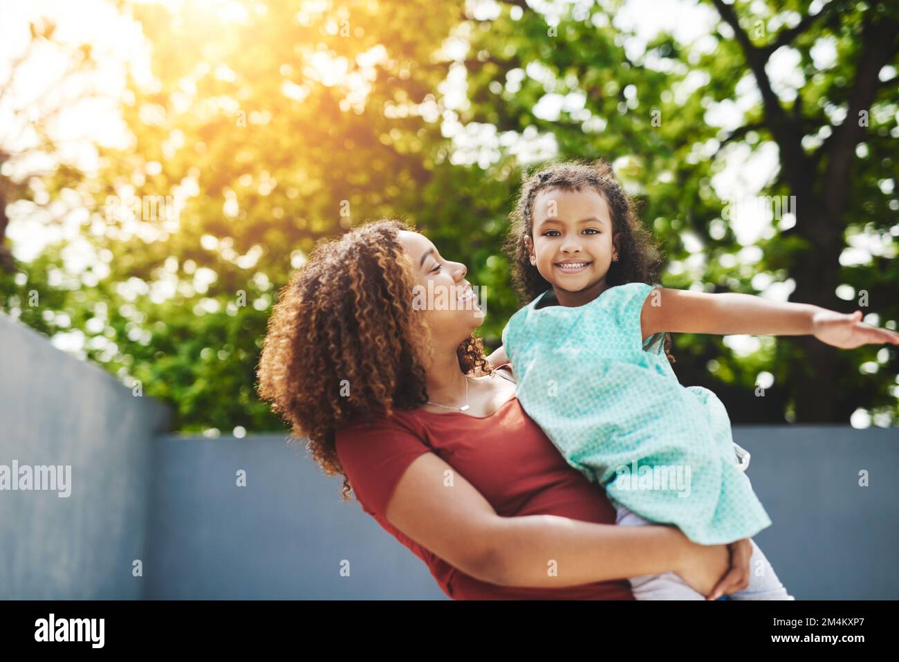 Dont be afraid to fly. a happy little girl and her mother having fun in ...