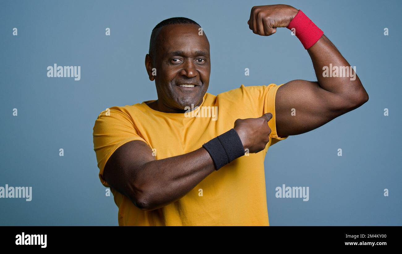 Smiling mature man sportsman standing in studio on gray background ...