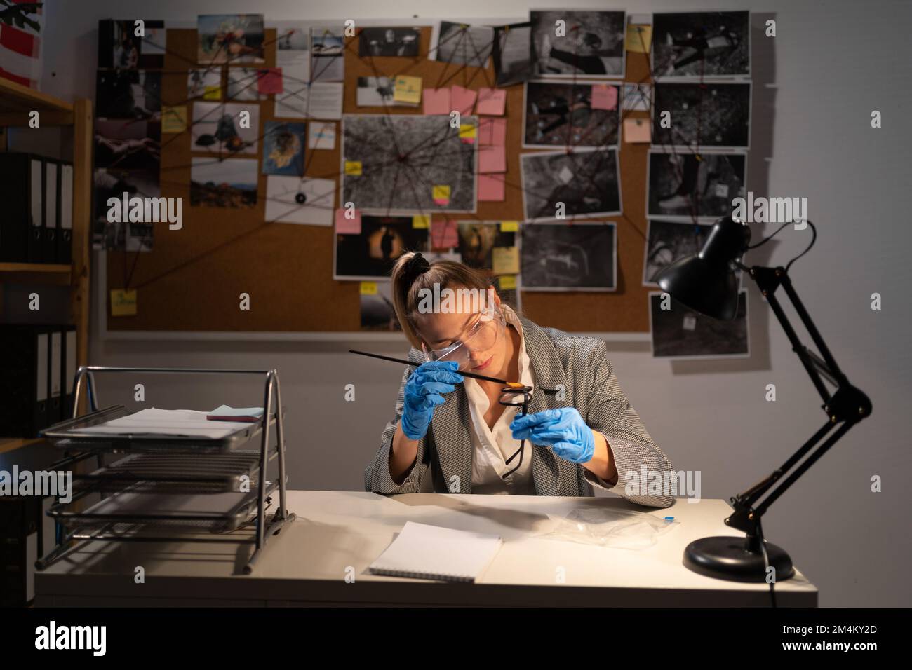 Female Criminologist In Gloves To Examine Evidence Glasses