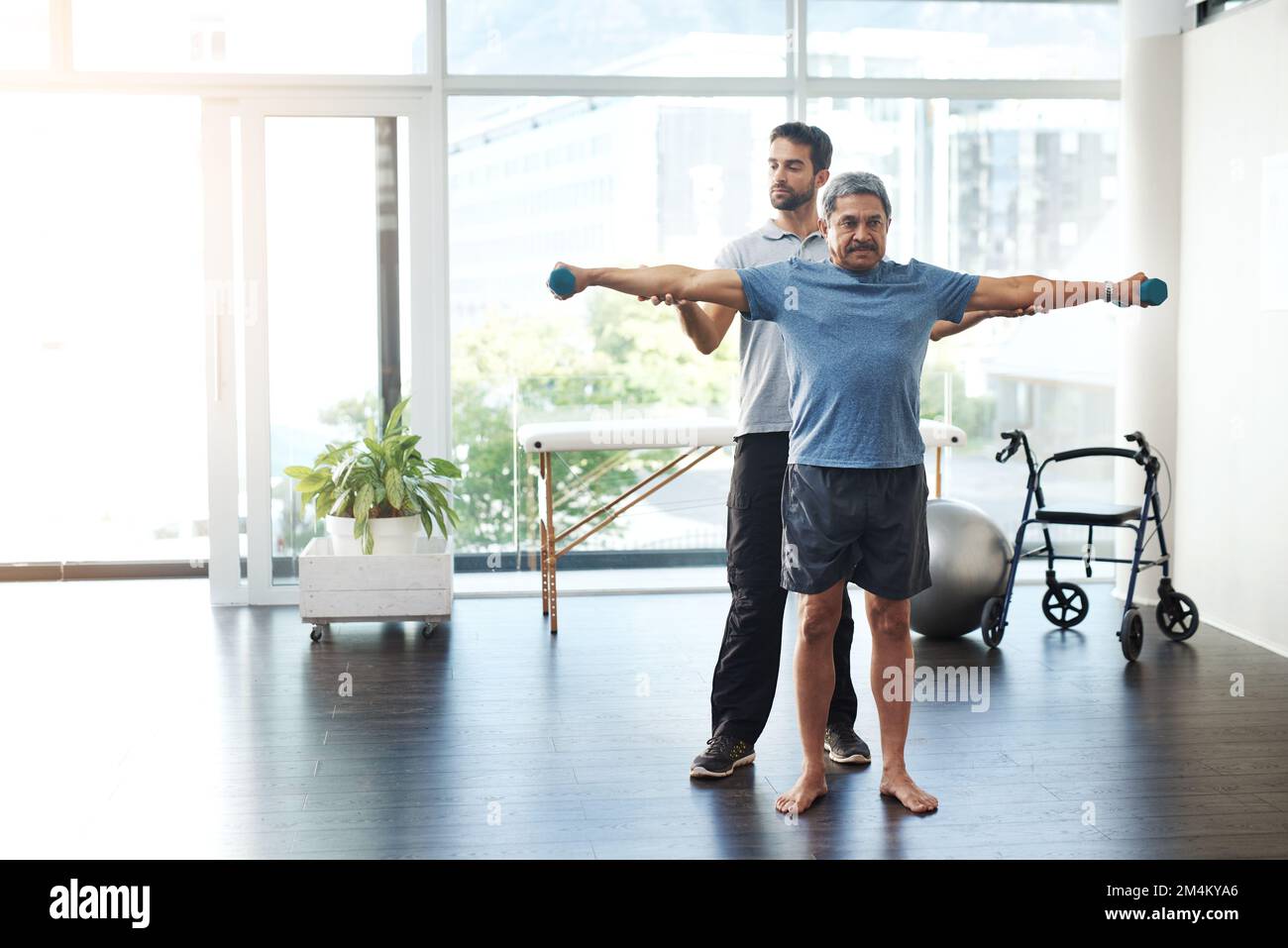 Nice and easy to begin with. a young male physiotherapist helping a ...