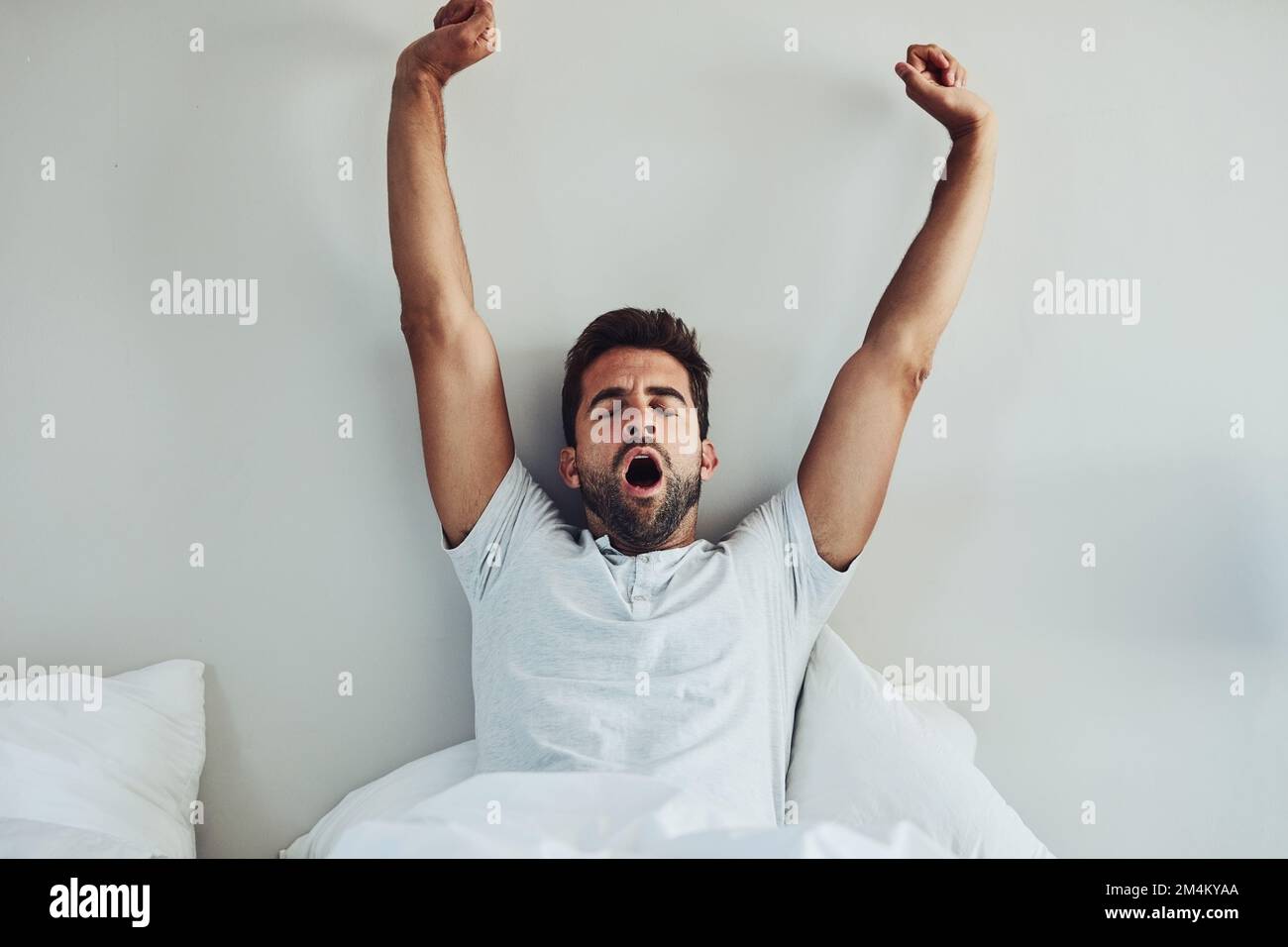 Time to wake up mister. a tired young man waking up after a good nights ...