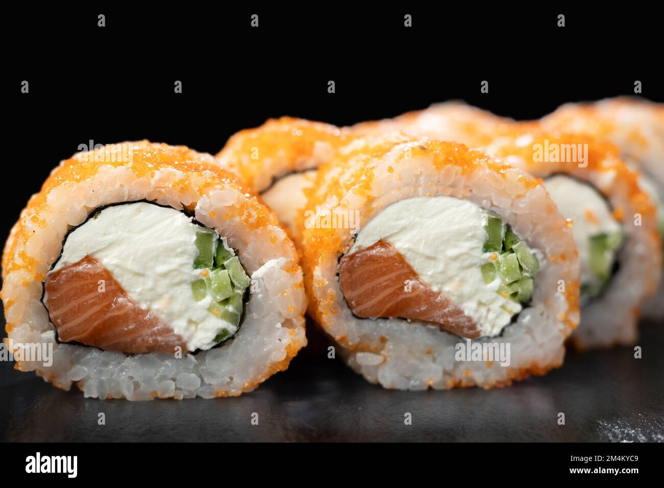 Sushi roll in flying fish roe Tobiko red caviar on black background ...