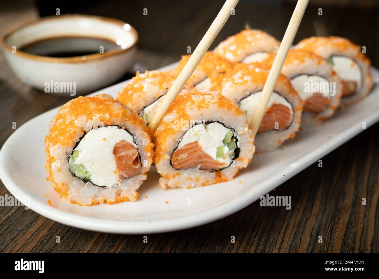 closeup of sushi rolls with chopsticks on white plate. Copy space Stock ...