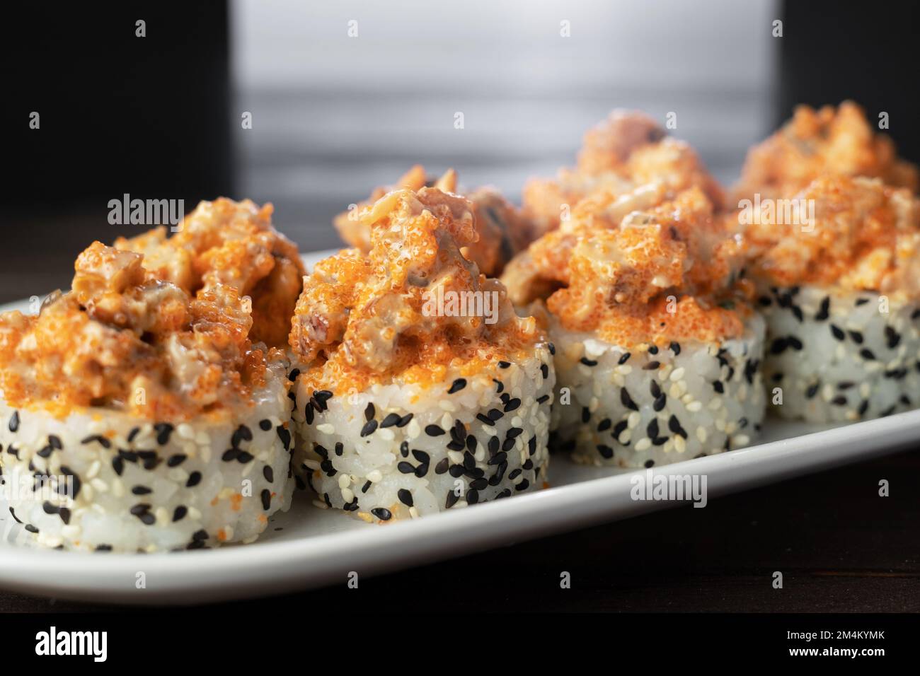 Japanese sushi volcano roll with eel, roe flying fish on top and sesame ...