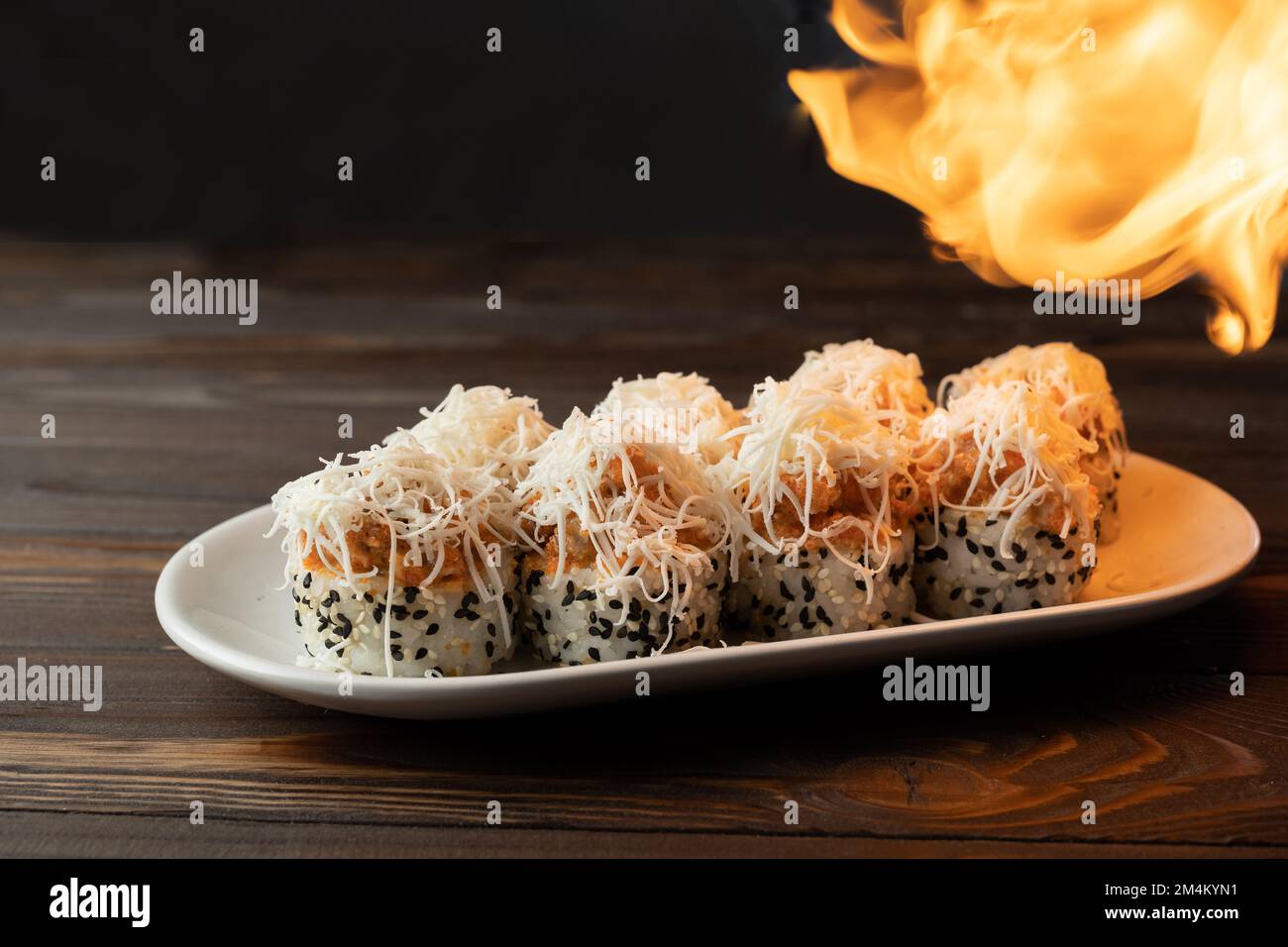 Preparing hot sushi with the help of fire on plate. Copy space Stock ...