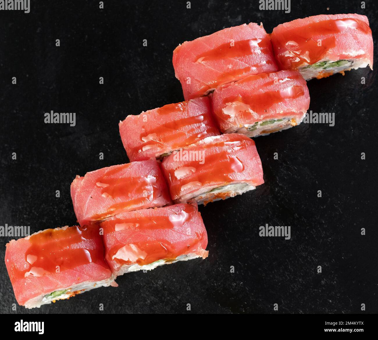 Sushi roll with tuna, tiger shrimp, cucumber, cream cheese on a black ...