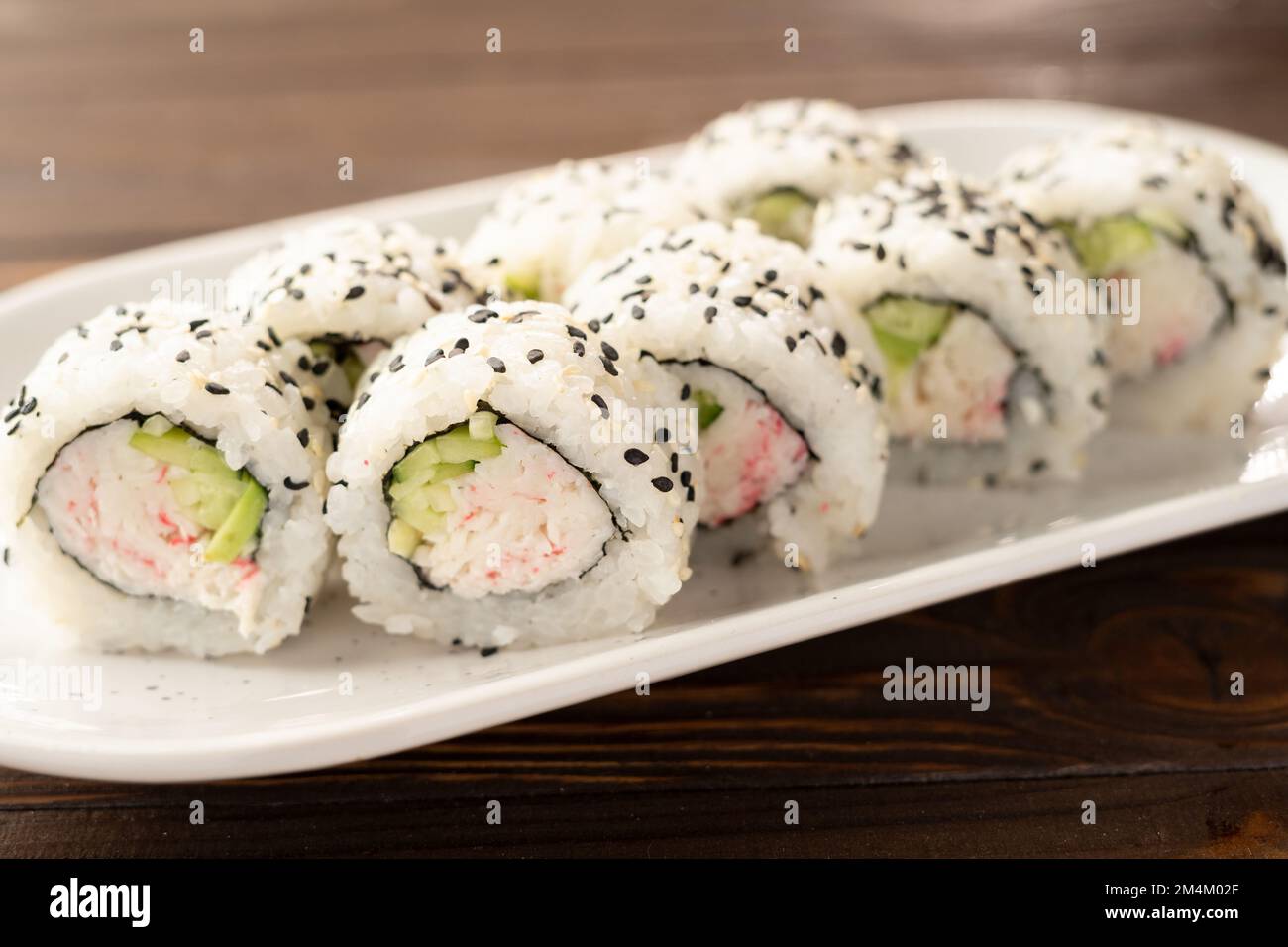 Maki California sushi with surimi crab, cucumber and sesame seeds on ...