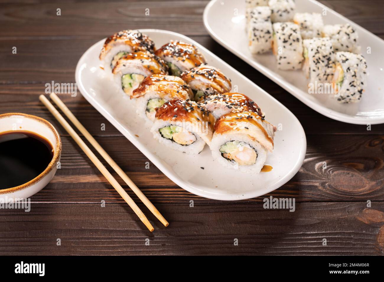 Sushi set with eel and sesame on white plate on wooden background with ...