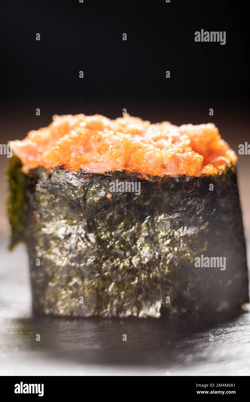Gunkan Maki Sushi with Seafood, caviar and Spicy Sauce. Spicy gunkan with tuna isolated on black ...