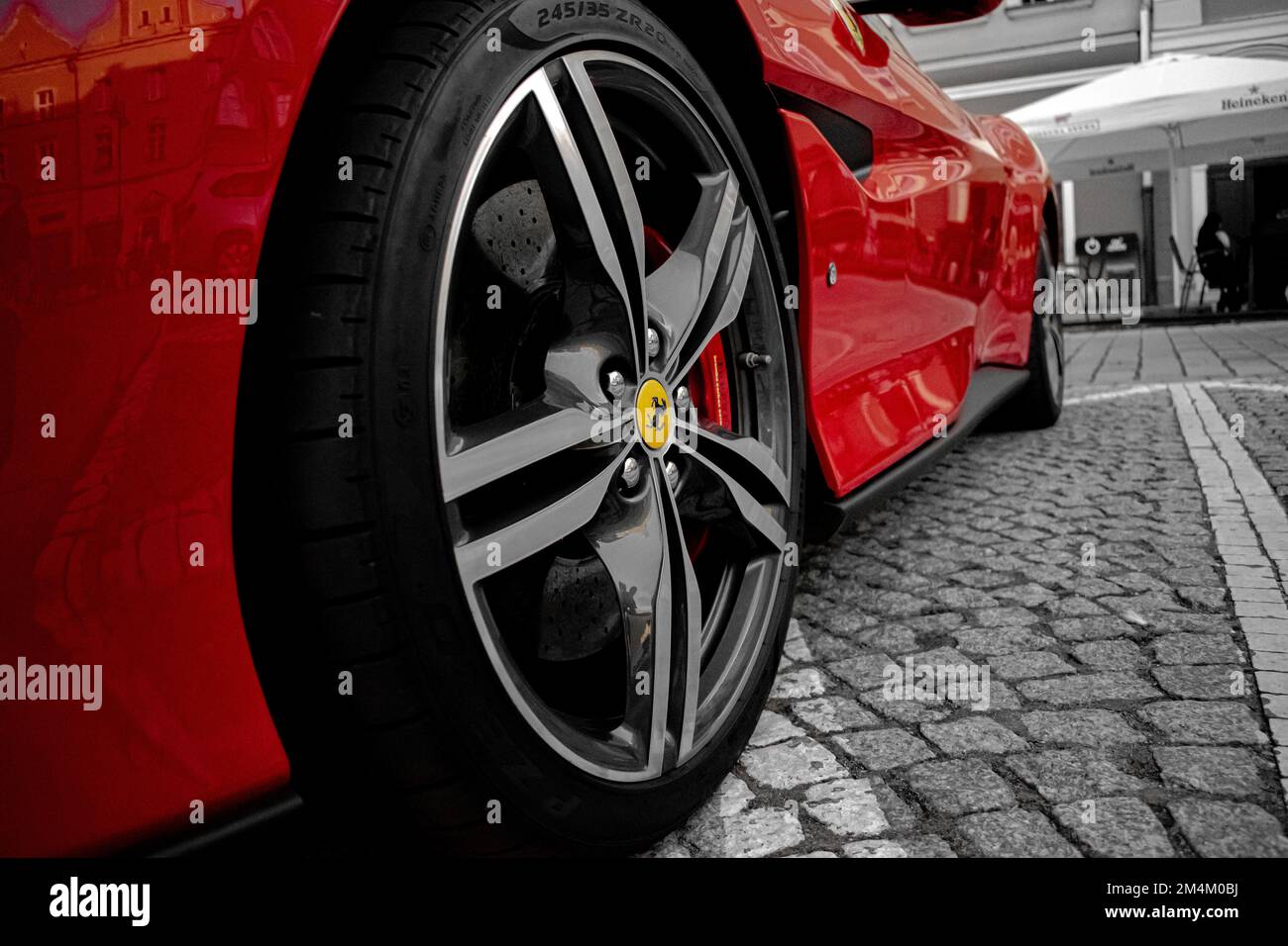 A closeup shot of a wheel of a red Ferrari car with its yellow logo in ...