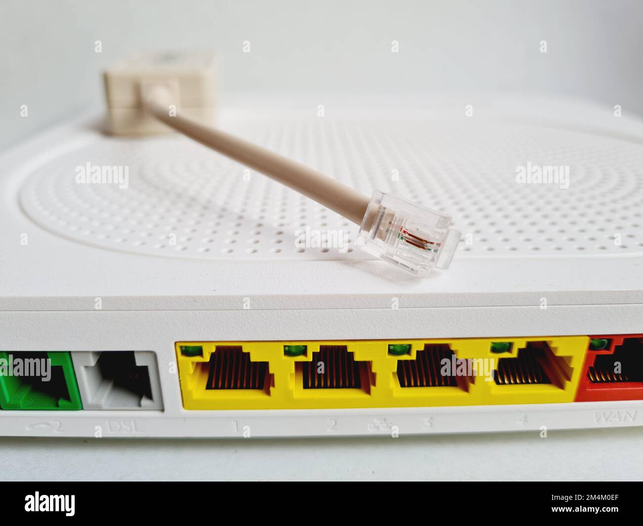 A closeup shot of a back of a modem router with colored network cable ...