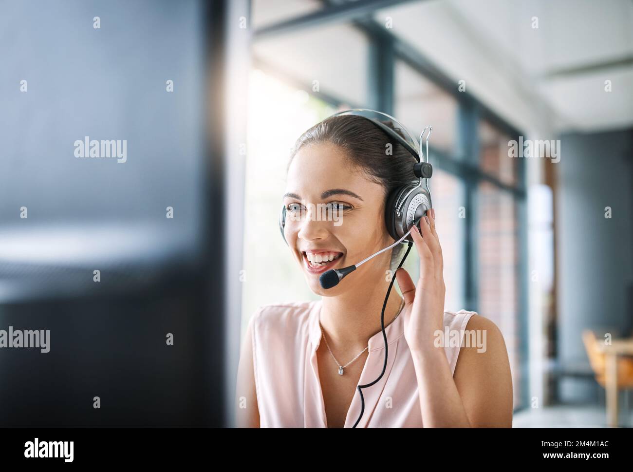 Shes more than happy to help. an attractive young woman working in a ...
