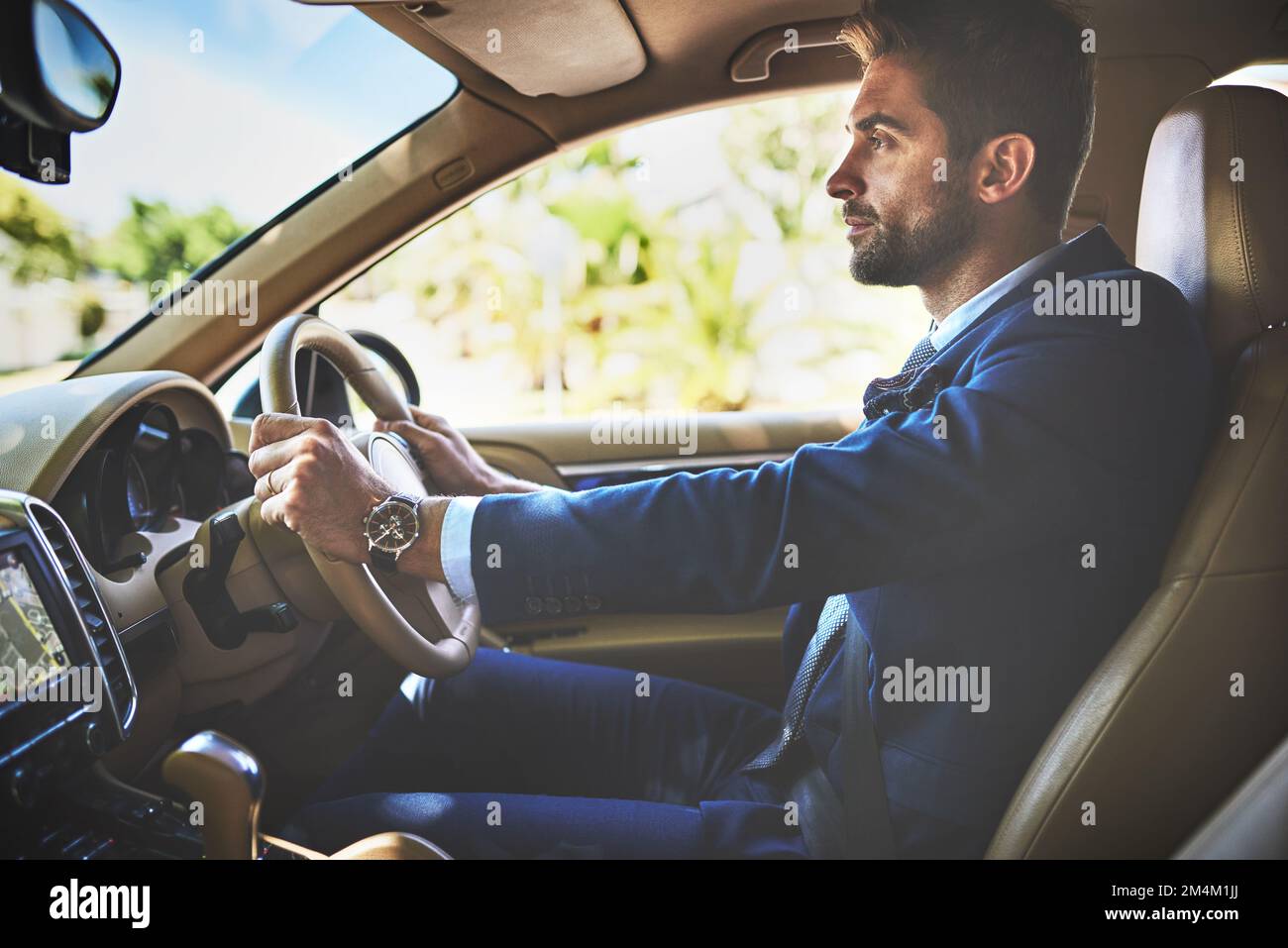 Hands on the wheel and eyes on the road. a cheerful young businessman ...