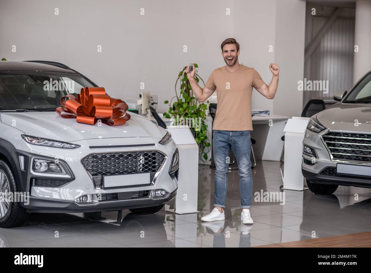 Happy and excited new car owner in a car salon Stock Photo - Alamy