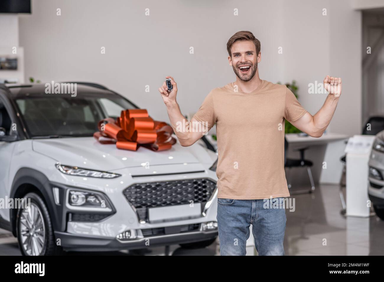 Happy and excited new car owner in a car salon Stock Photo - Alamy