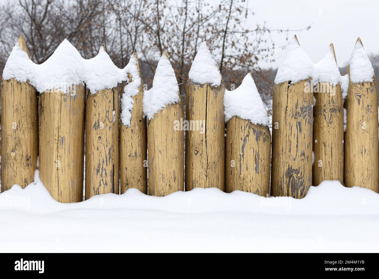 log fence covered with snow in winter. snow covered fence Stock Photo ...