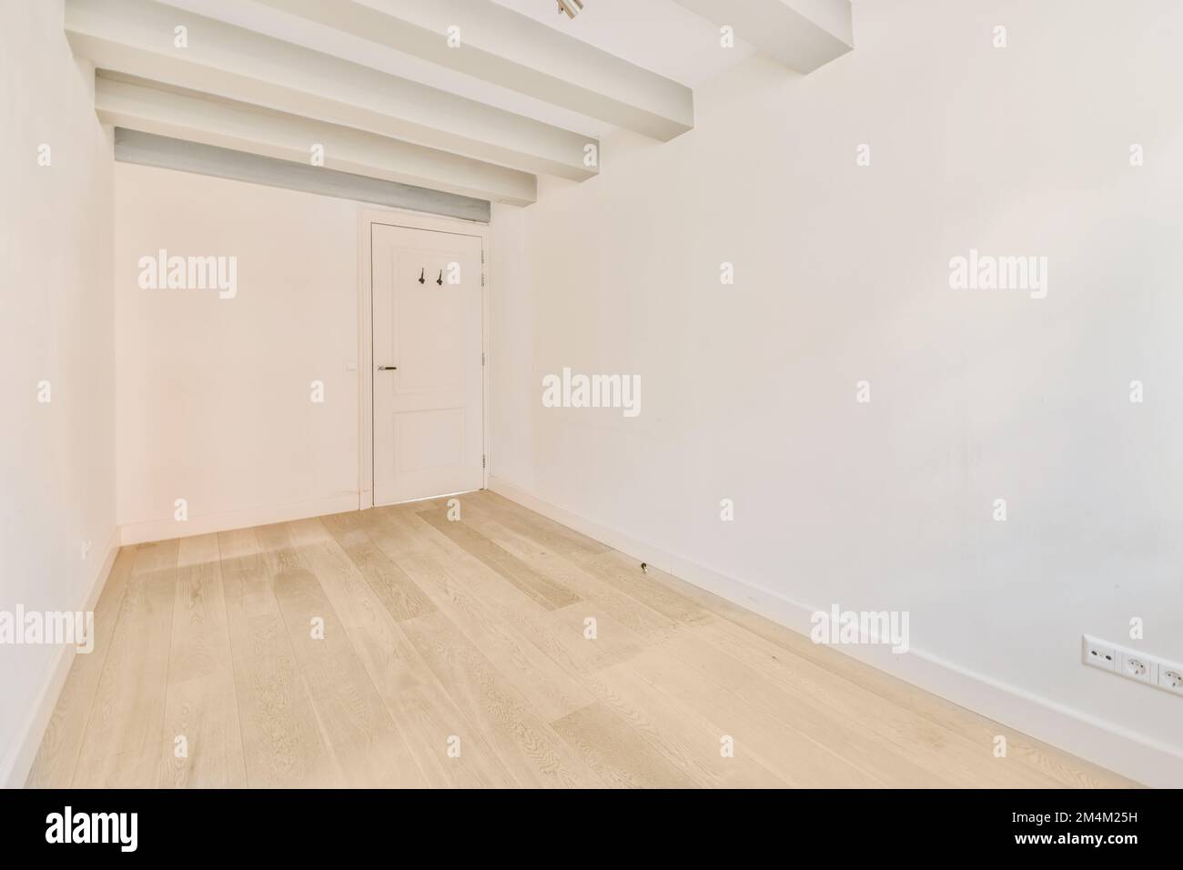an empty room with white walls and wood flooring on the right, there is ...