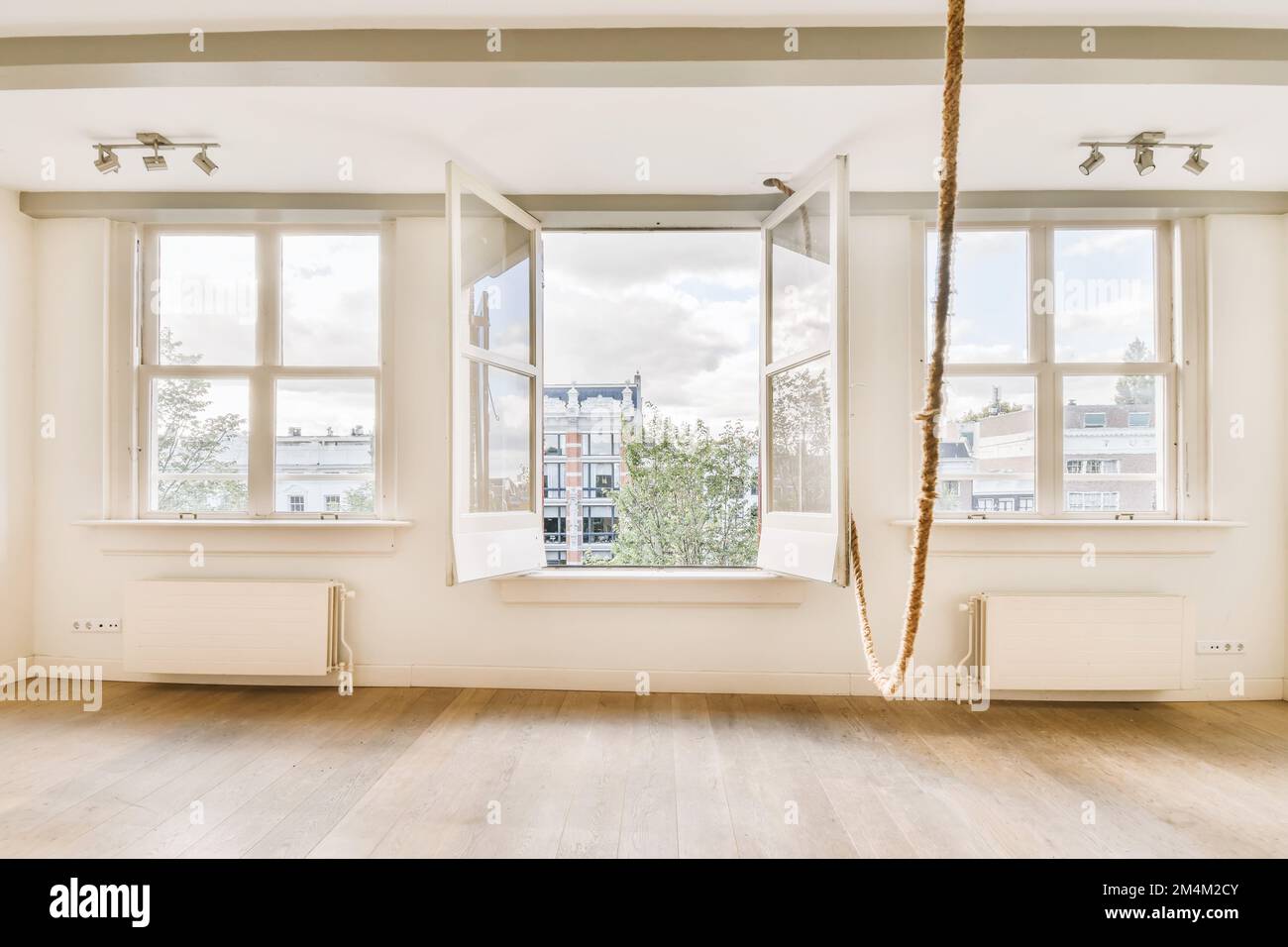 an empty room with two windows and a rope hanging from the ceiling to ...