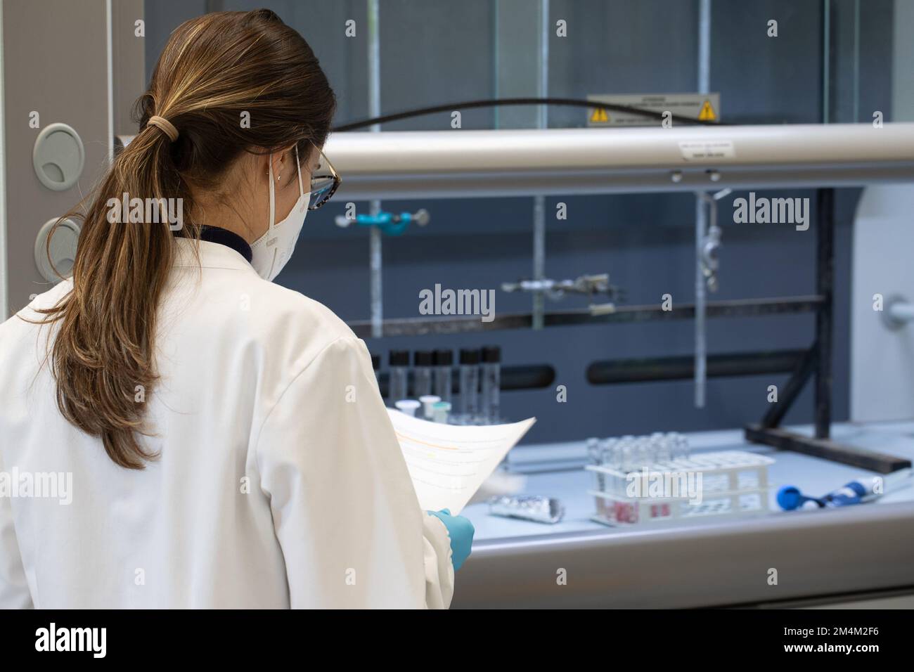 Female scientist with an experimental protocol in her hand while ...