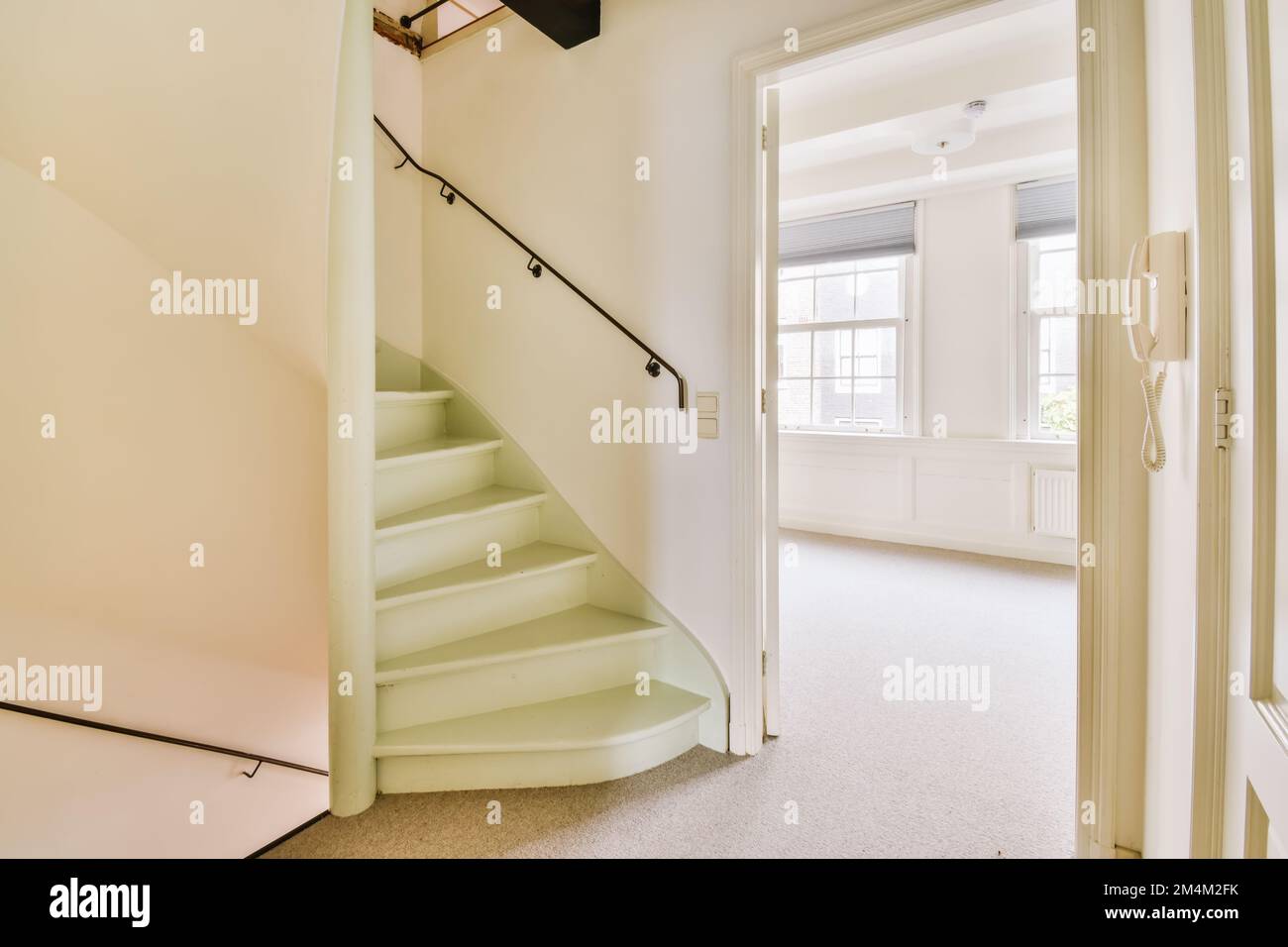 a room with some stairs and a light fixture on the right hand side of ...