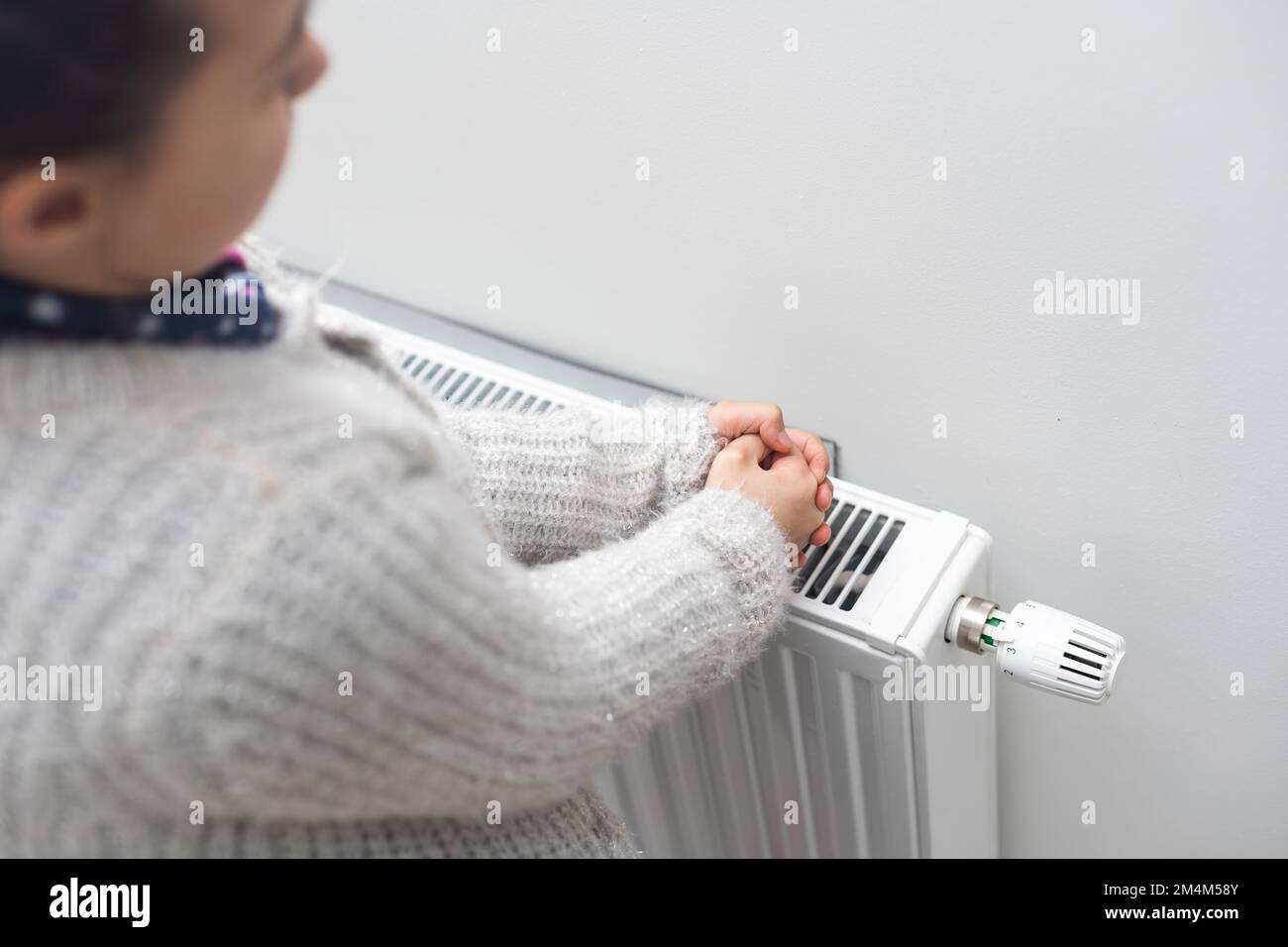 Children's hands warm on the radiator Stock Photo - Alamy