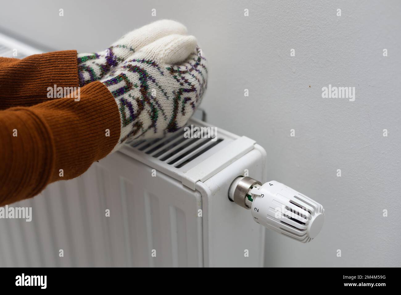 Closeup of woman warming her hands on the heater at home during cold ...