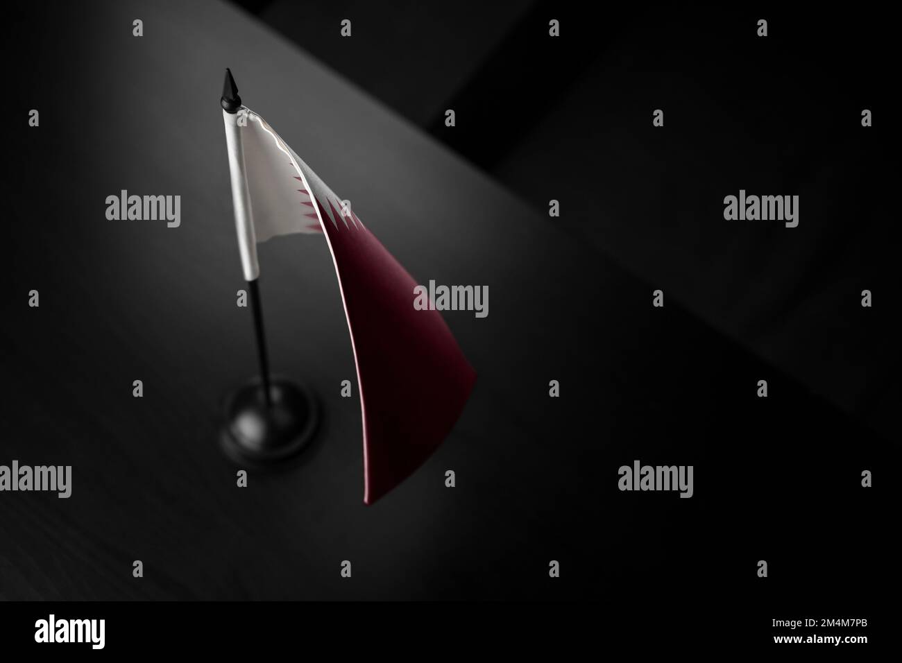 Small national flag of the Qatar on a black background Stock Photo - Alamy