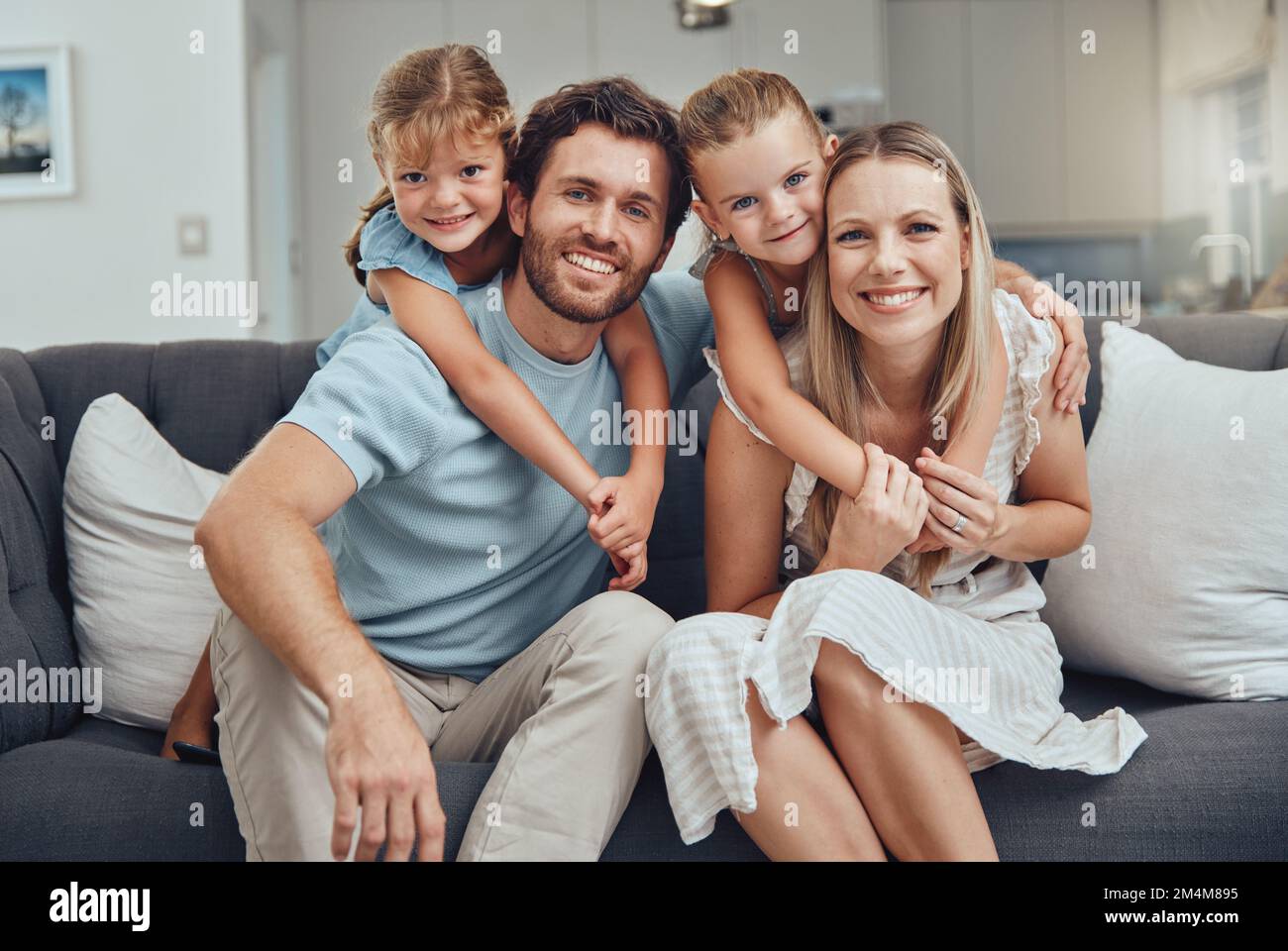 Portrait, mother and father with girls, smile and bonding on sofa for ...