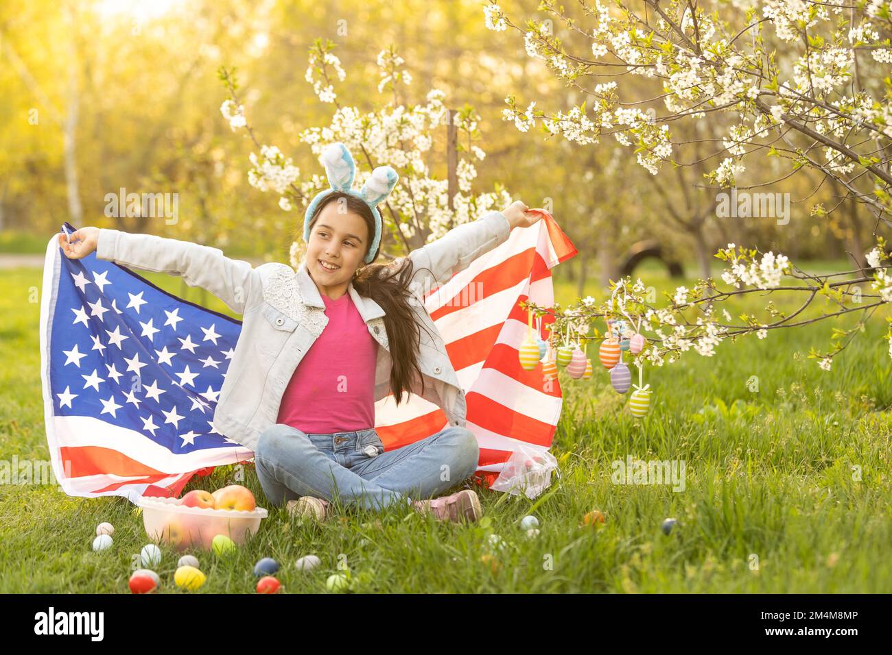Girl kid in rabbit bunny ears on head with colored eggs and american ...