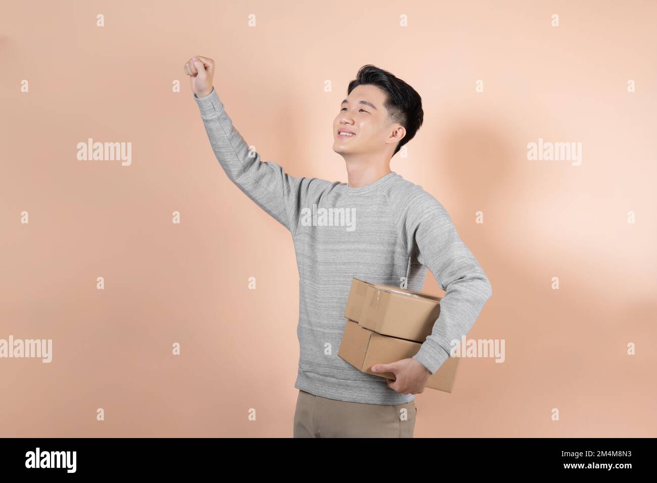 Portrait smiling Asian man holding post boxes standing over isolated ...