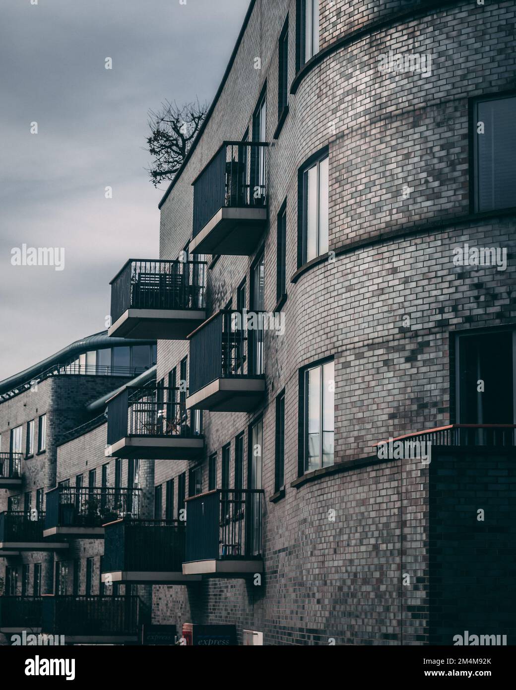A vertical of the balconies of a building made out of grey bricks ...