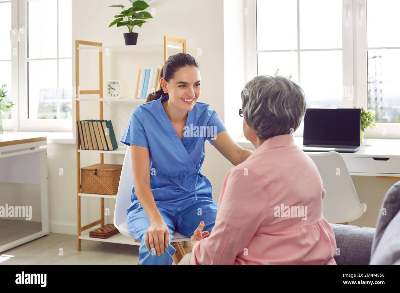 Young nurse or doctor talking to senior woman, trying to support and ...