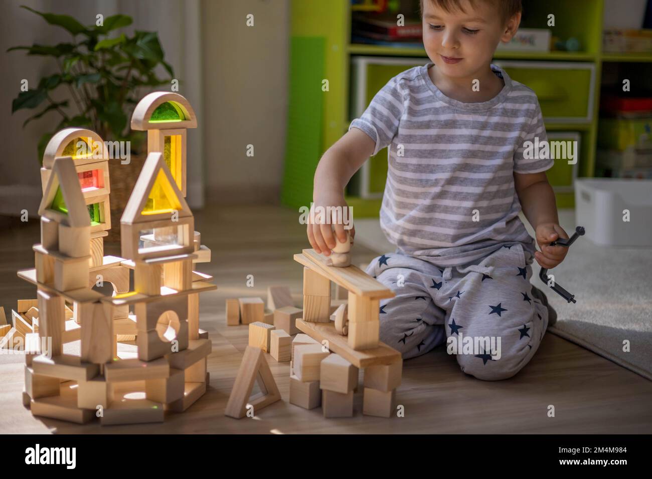 Cute baby boy building tower wooden bricks Montessori materials at ...